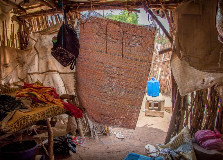 A fraying straw mat takes the place of a door in Fatima’s house ...